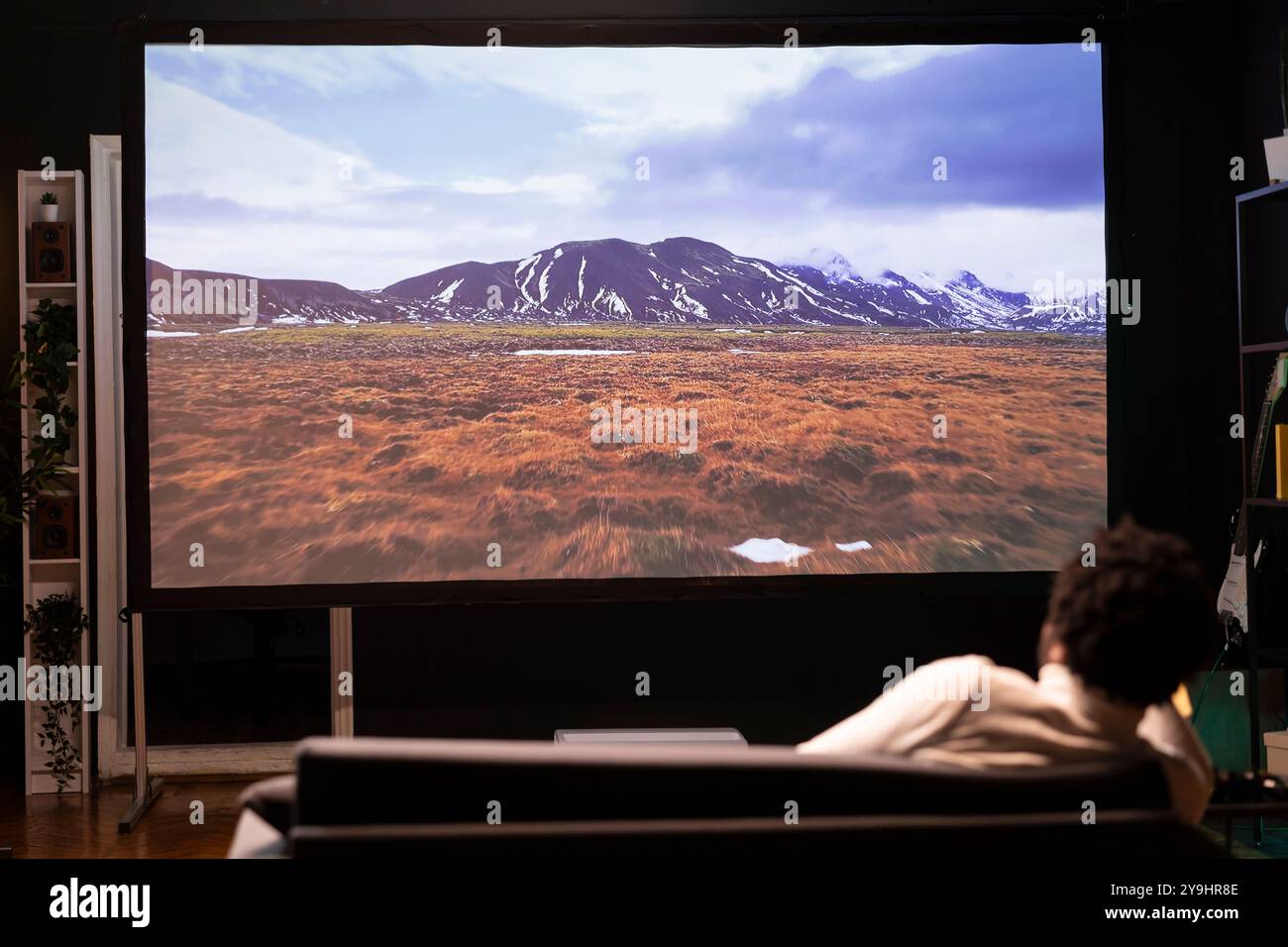 Man lounged on couch watching travel documentary with beautiful ...