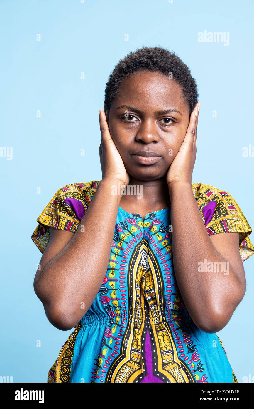African american model covering her ears in studio, presenting three ...