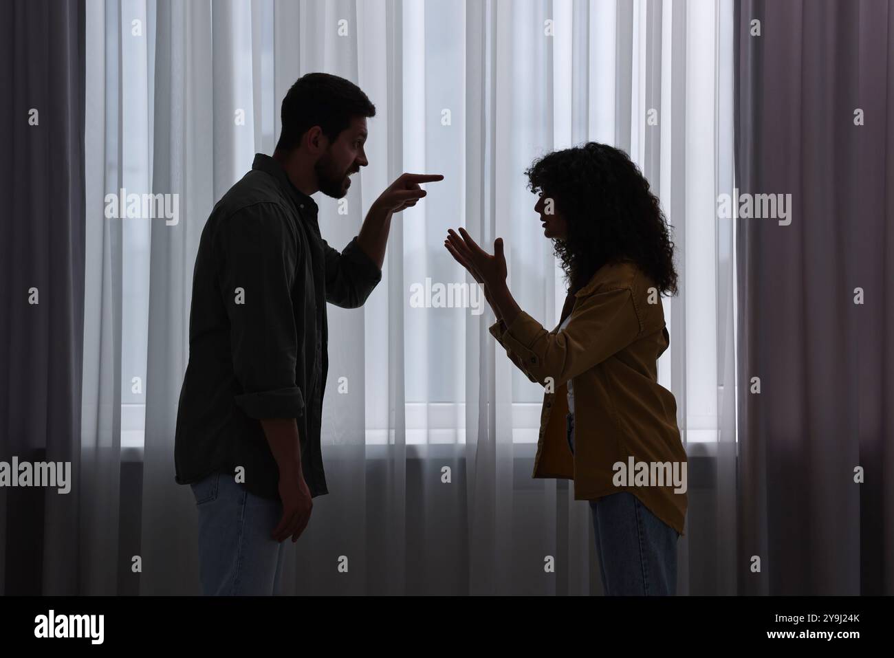 Emotional couple arguing indoors at night. Relationship problems Stock ...