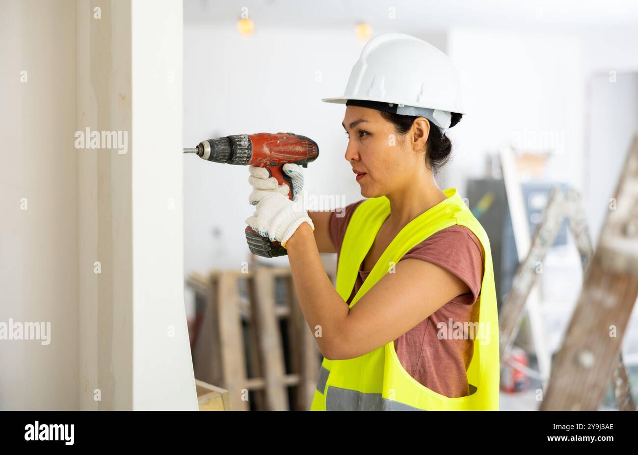Confident female construction worker holding an electric drill hi-res stock photography and ...