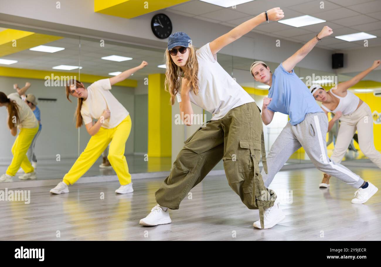 Teenage girl in sunglasses and cap training breakdance Toprock moves in dance hall Stock Photo ...