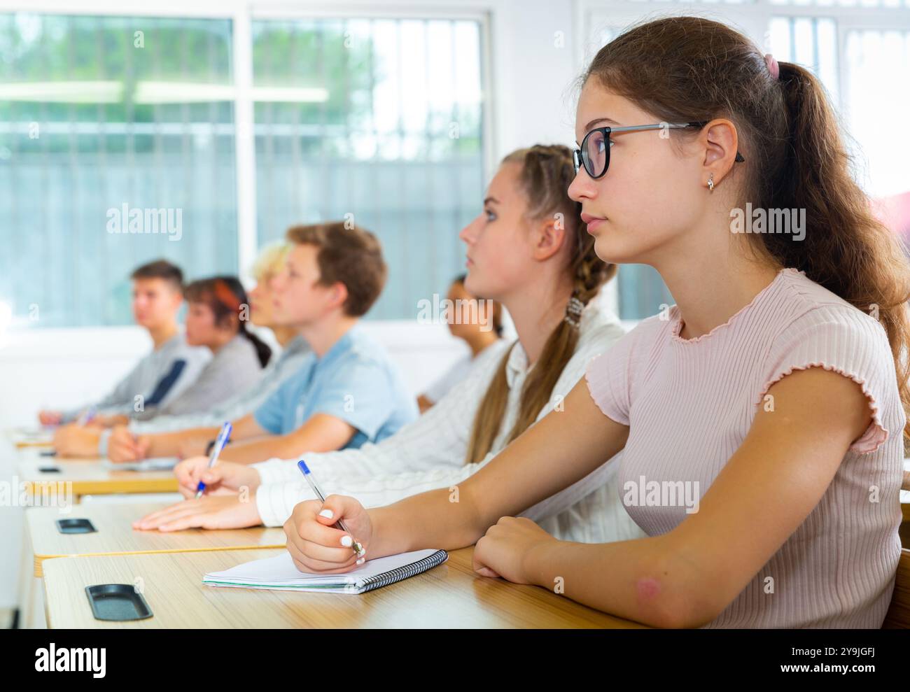 Side view of student group working on lecture in classroom Stock Photo ...