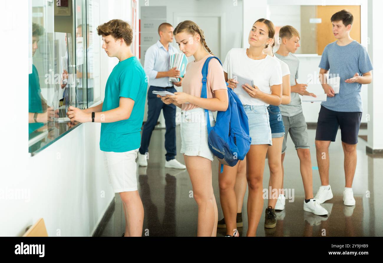 Teenagers applicants submit documents to admissions office of ...