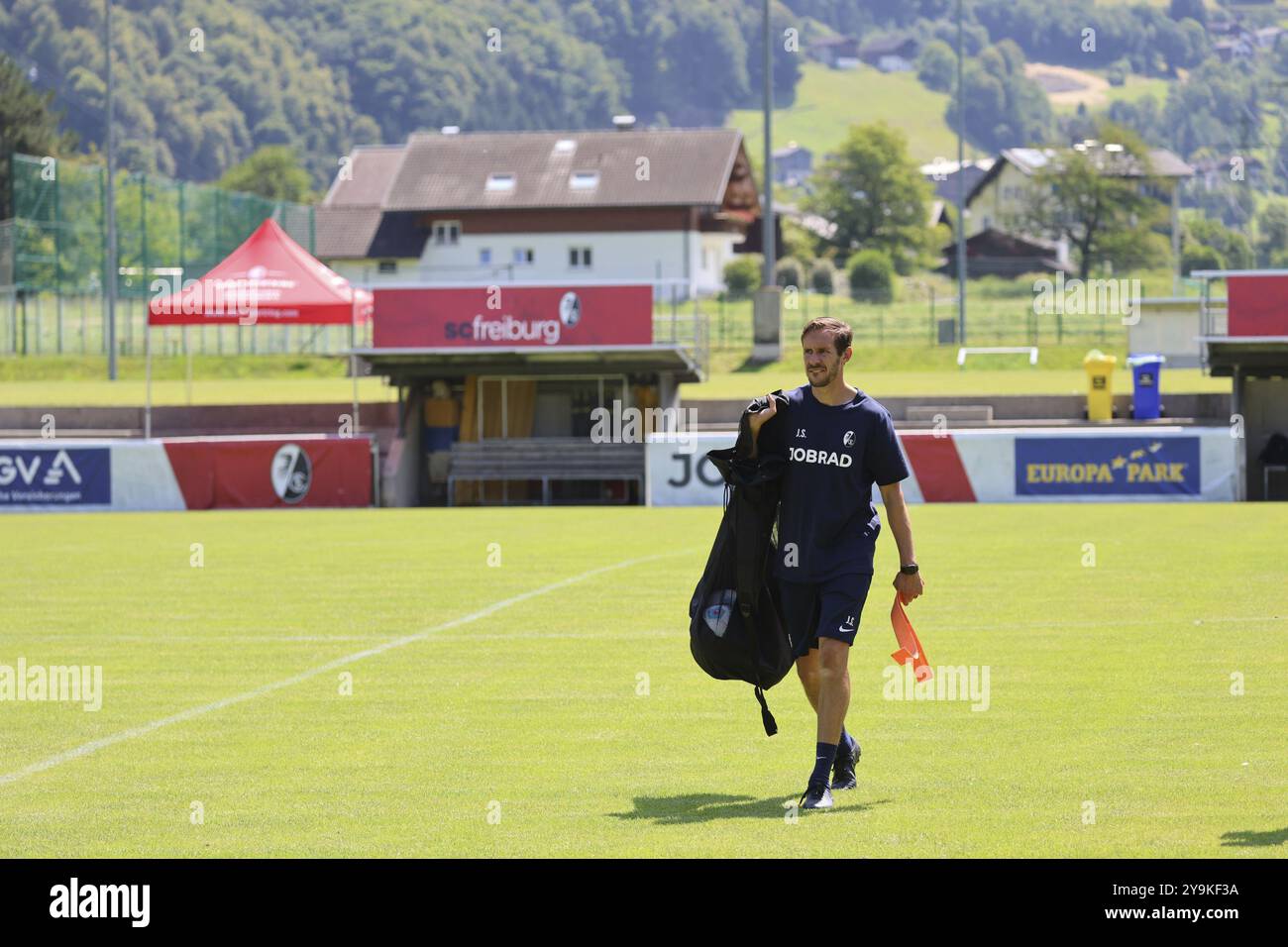 Coach Julian Schuster (SC Freiburg) lends a hand, dragging a ball sack ...