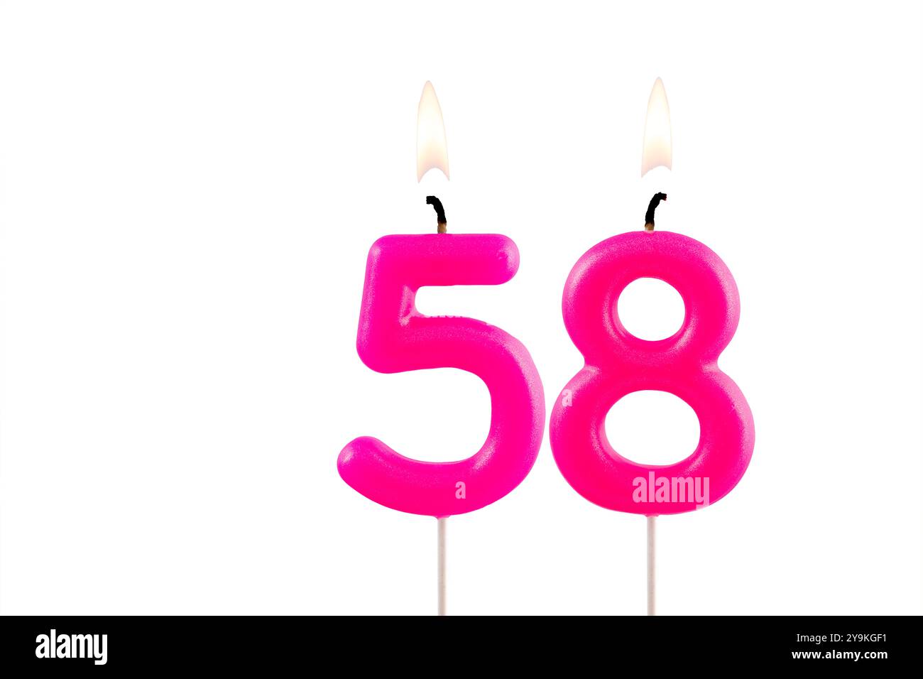 Pink number 58 birthday candle lit on white background Stock Photo - Alamy