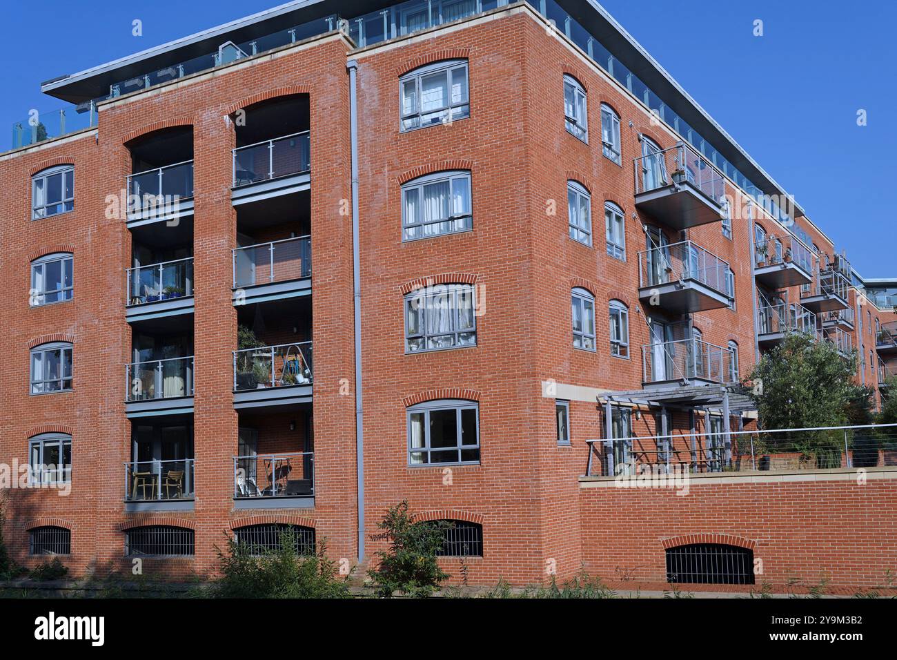 Medium size red brick apartment building with balconies Stock Photo - Alamy