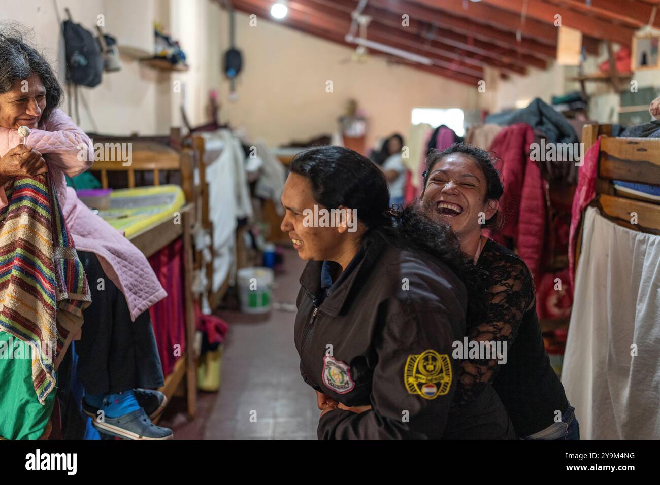 A prisoner, right, playfully hugs a female prison guard at the women's ...