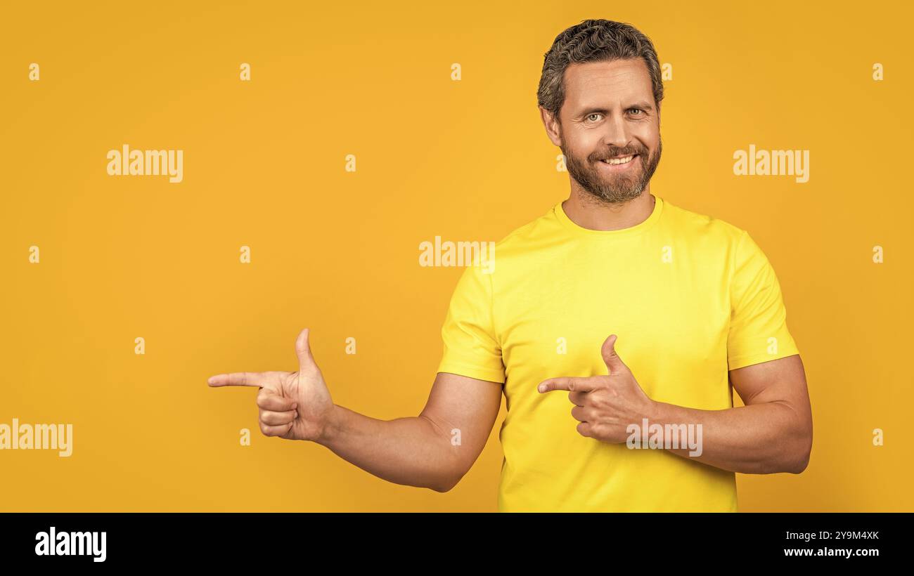 man presenting advertisement isolated on yellow, copy space. man ...
