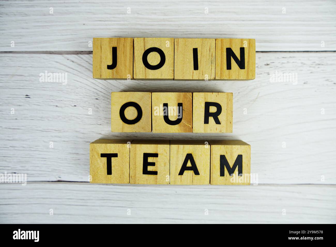 Join our team alphabet letters with wooden block top view on wooden ...
