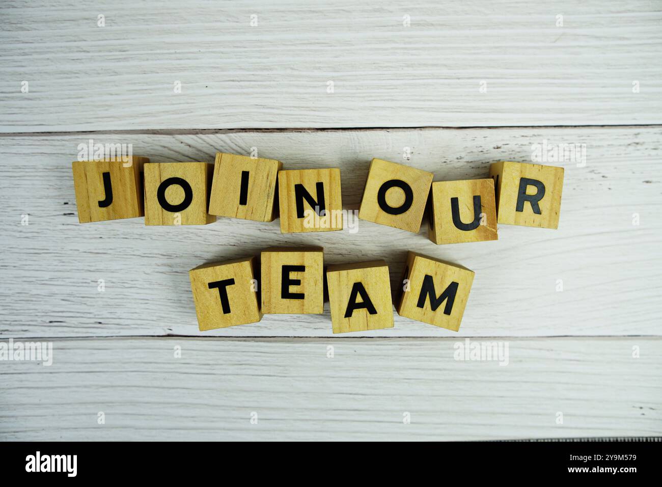 Join our team alphabet letters with wooden block top view on wooden ...