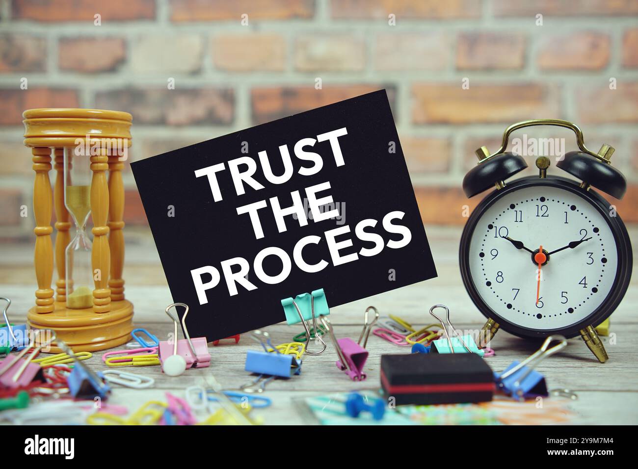 Trust The Process text on paper card with hourglass and stationary on ...
