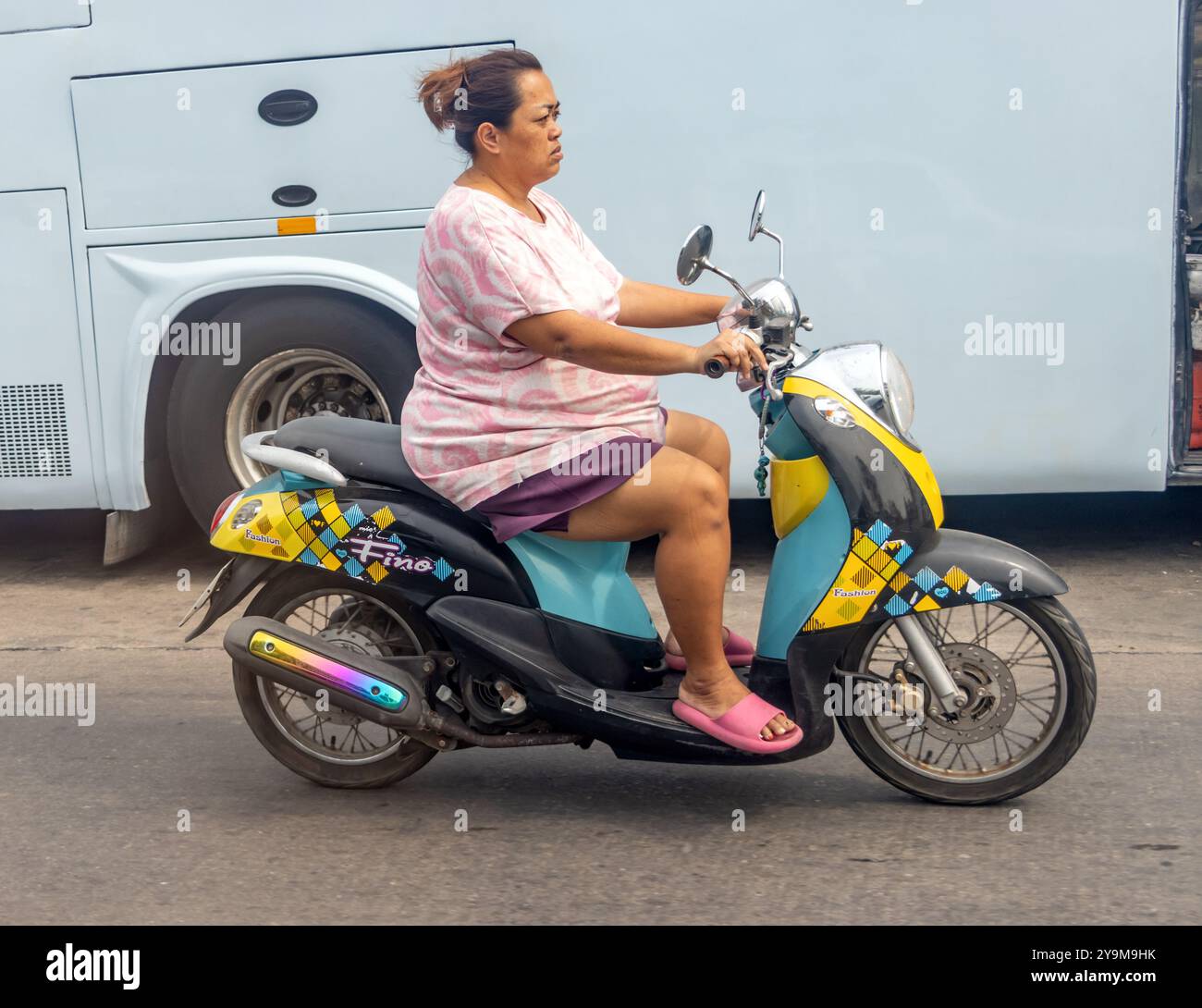 BANGKOK, THAILAND, MAR 09 2024, A woman rides a motorcycle in city ...