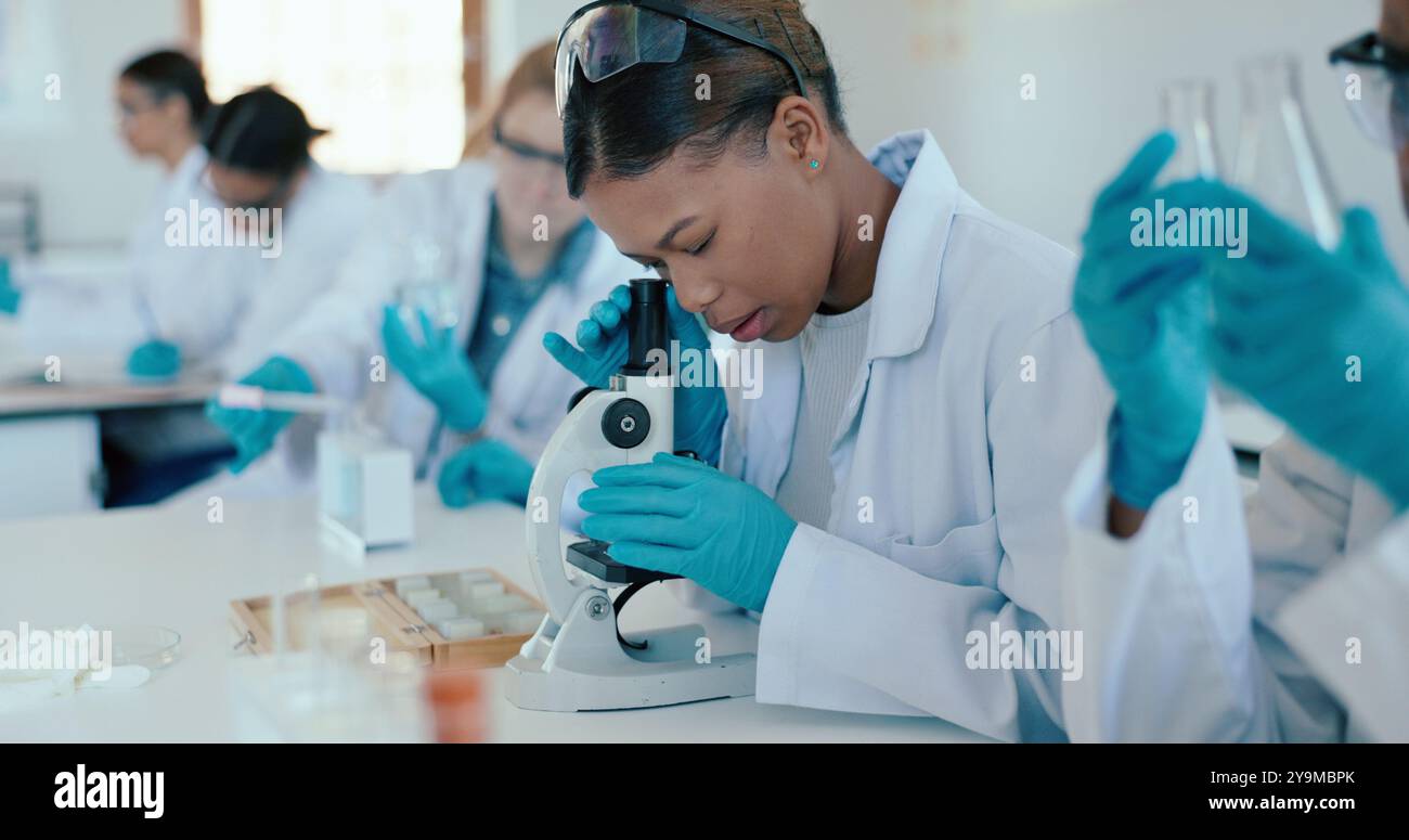Science, student and analysis with microscope in classroom for sample ...