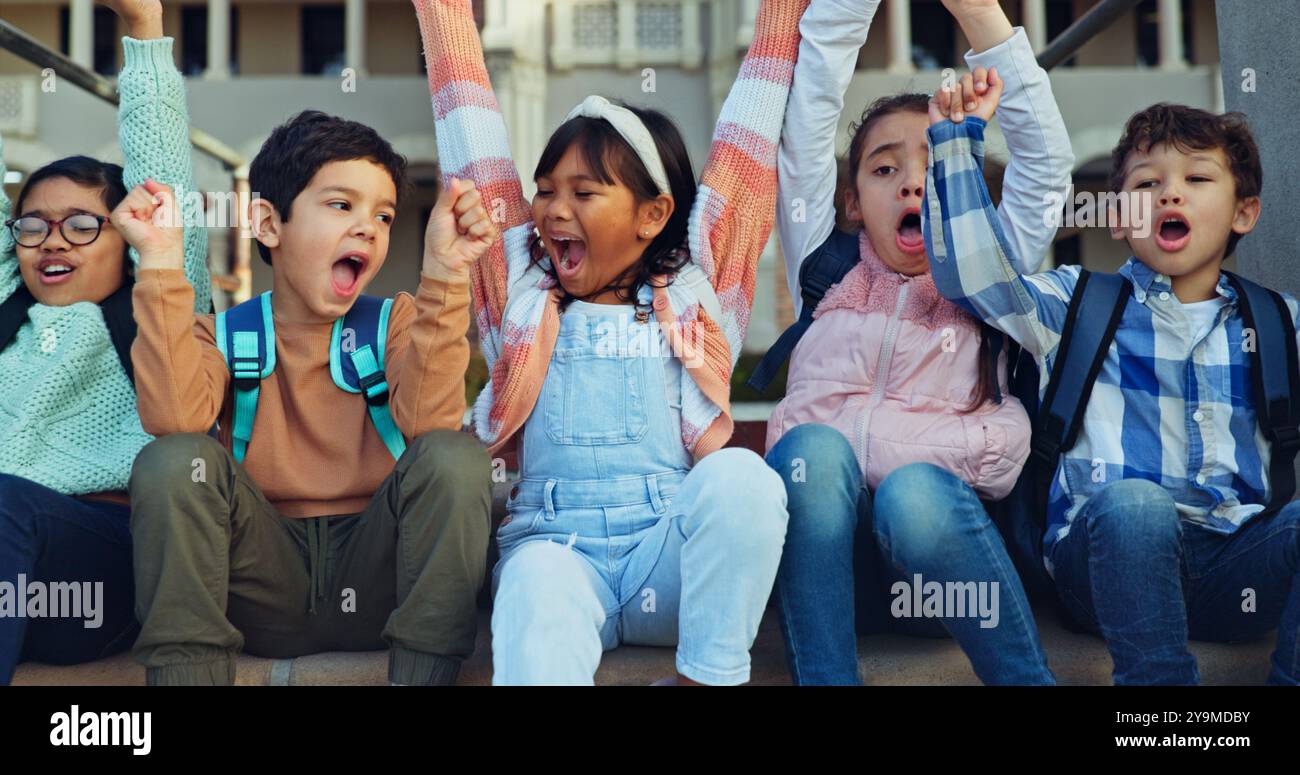 Children, group and celebration on stairs at school with hands up ...