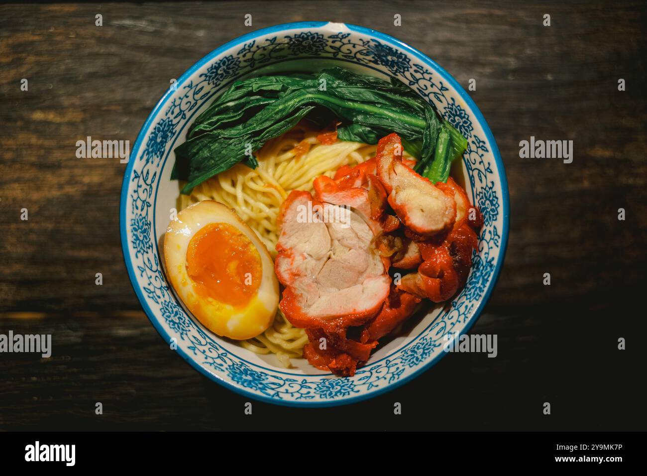 Chinese fried noodles in a bowl with Char Siu, hard-boiled egg, and a ...