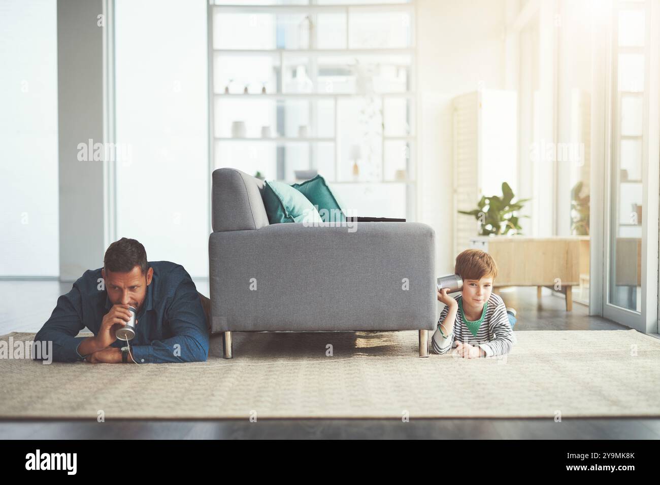 House, father and son on floor, tin can and playful with communication ...