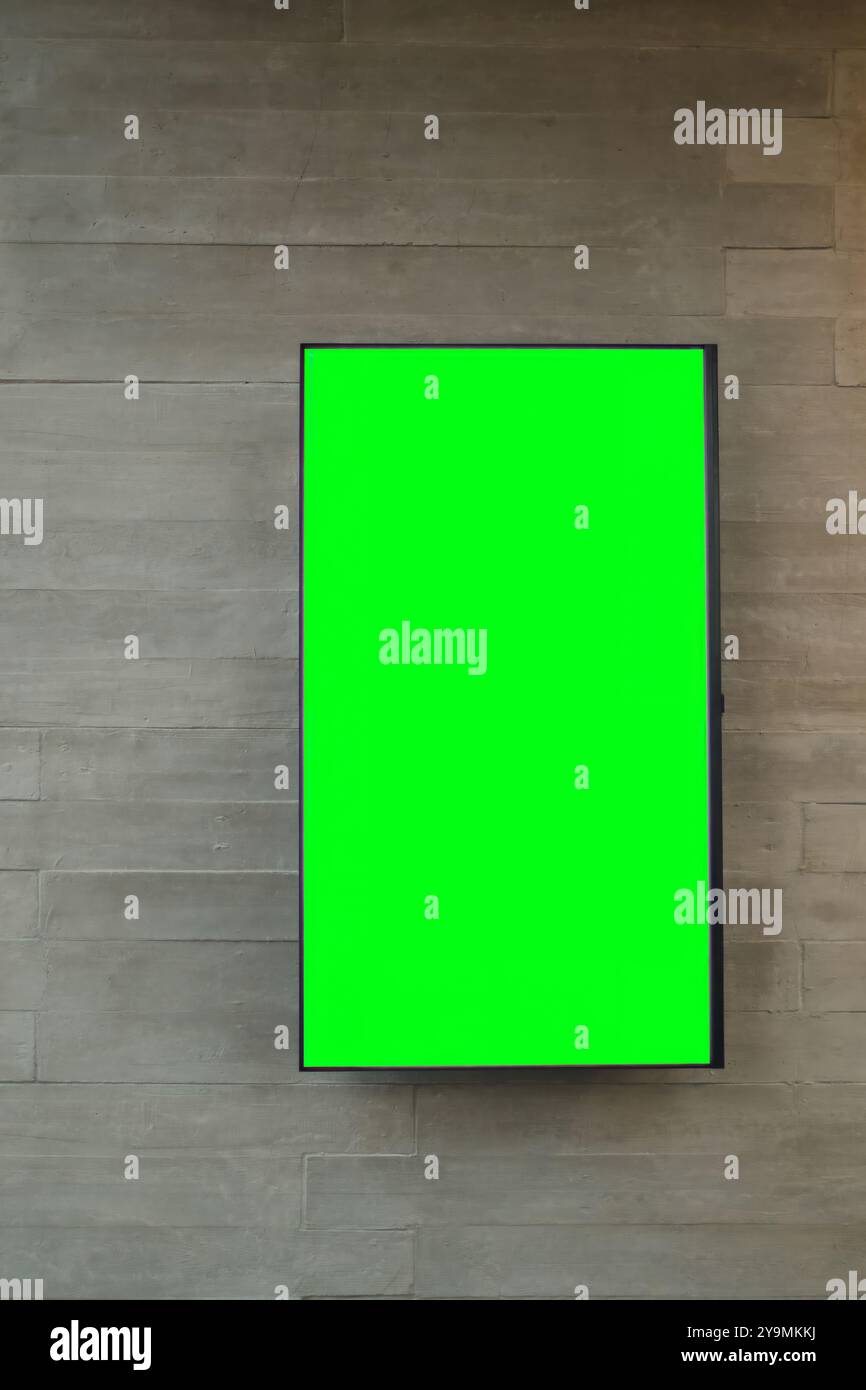 A TV with vertical oriented mounted on a modern stone wall showing ...