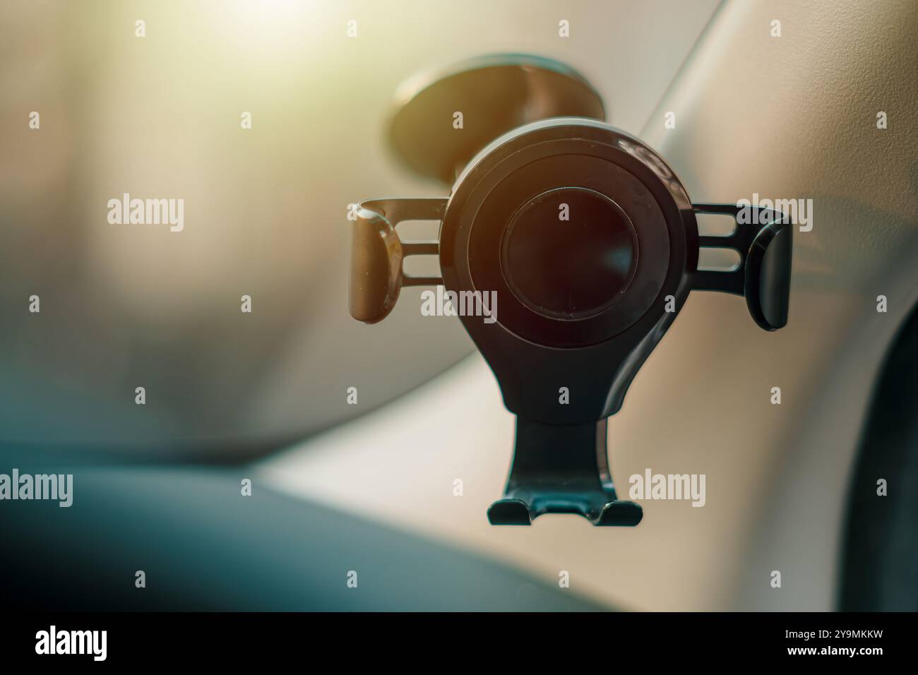 Black phone holder with gravity mount. Bokeh background with sunlight ...