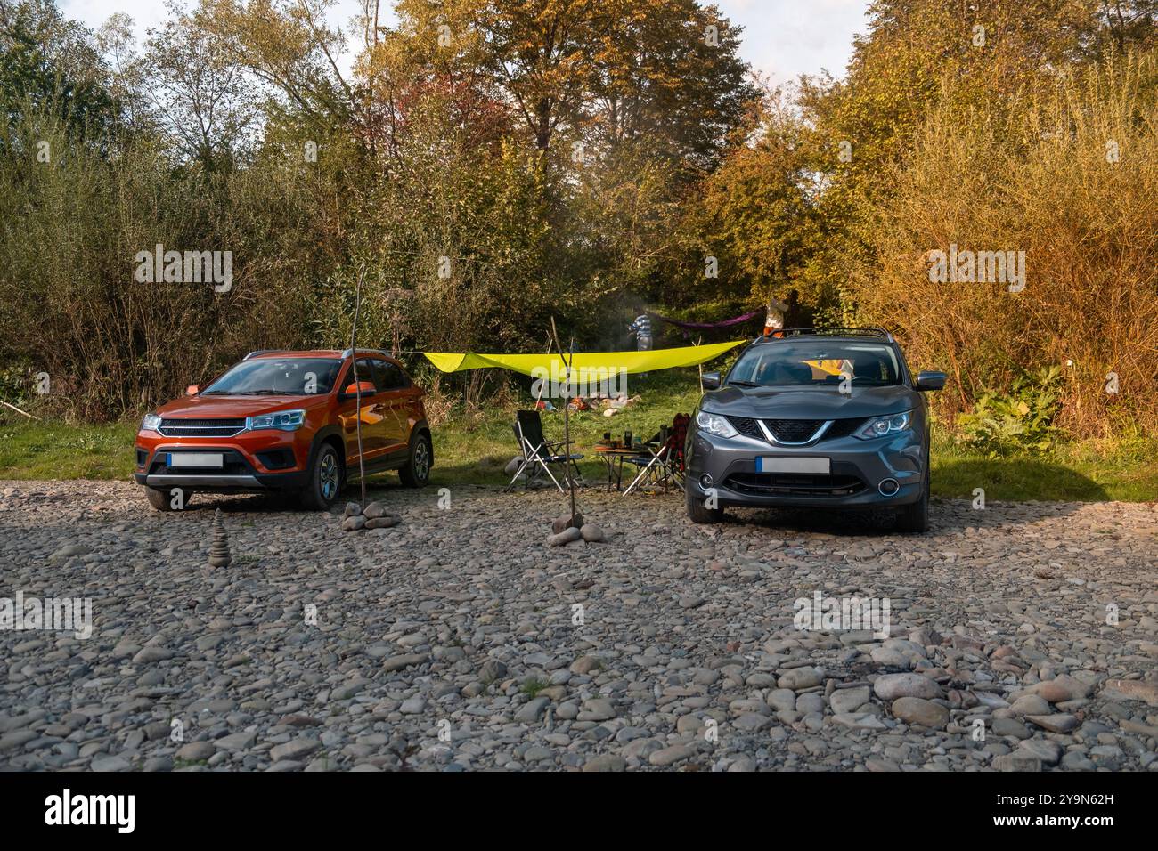 Camping Setup by the Riverbank with Cars Stock Photo - Alamy