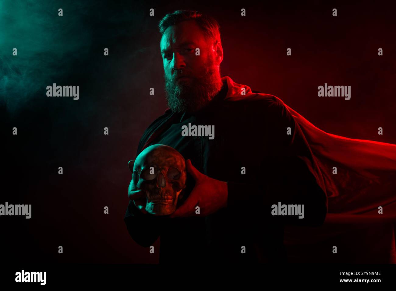 Photo of spooky character scary man holds human skull isolated on dark ...