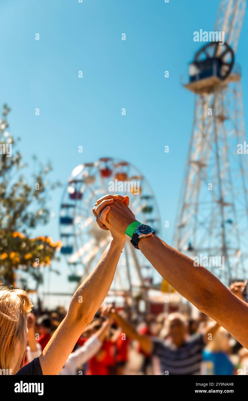 Two people with arms raised holding hands dancing the traditional ...
