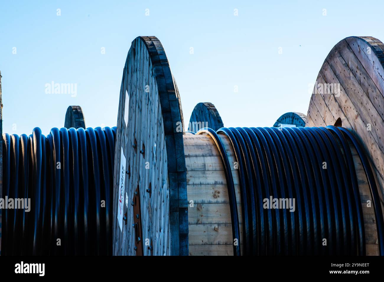 Large wooden cable drums with black cable Stock Photo - Alamy