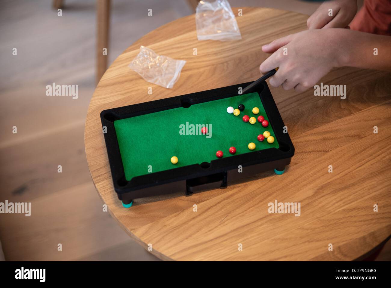 Kids playing a tiny billiards game Stock Photo - Alamy