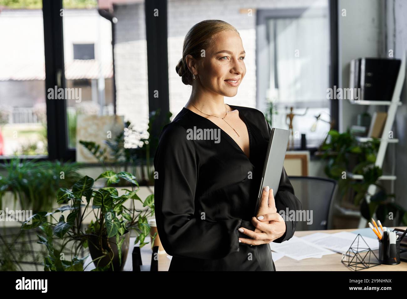 A young plus size woman stands confidently in her office, engaged in ...
