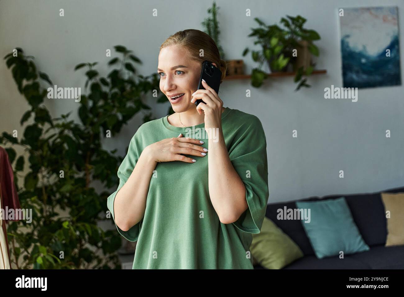 A young, beautiful plus size woman at home smiles while talking on the ...