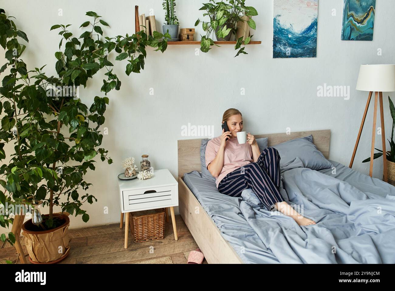 A young, beautiful plus size woman sips tea and relaxes in a serene ...