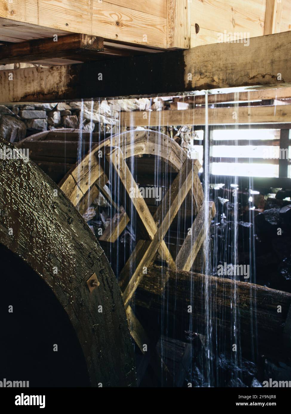 Old wooden waterwheel splashed by falling water. Picture from a ...