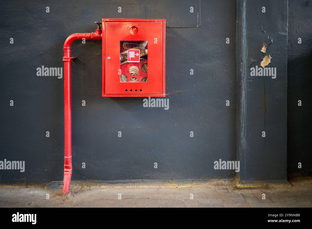 Fire hose in red box. Pipe roll for fire emergency in red metal cabinet ...