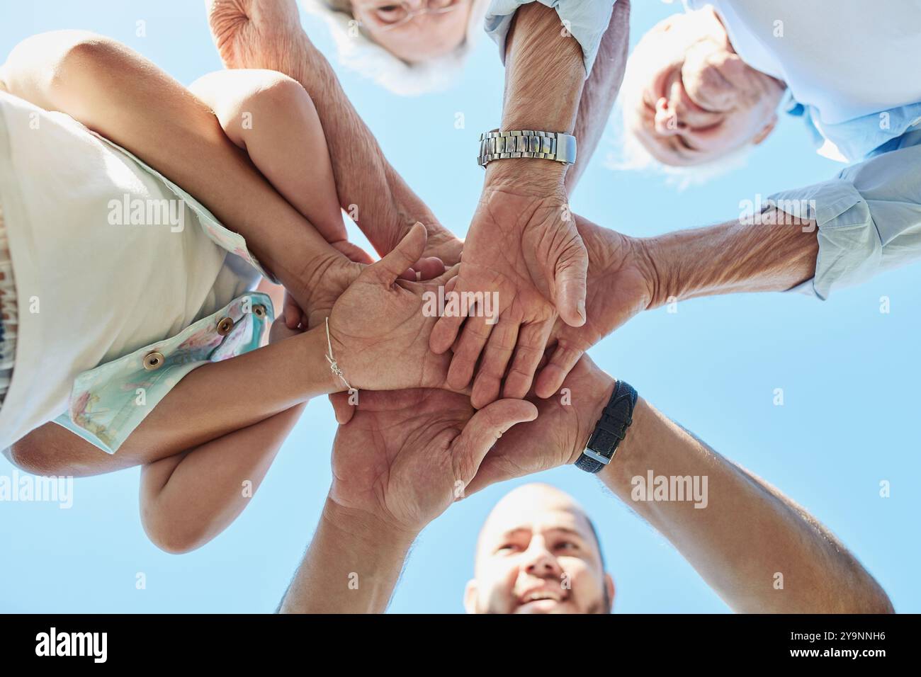 Family, hands and huddle outdoor for support, solidarity or connection ...