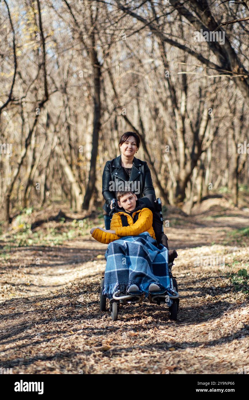Mother and child with special needs on forest walk, nature therapy ...
