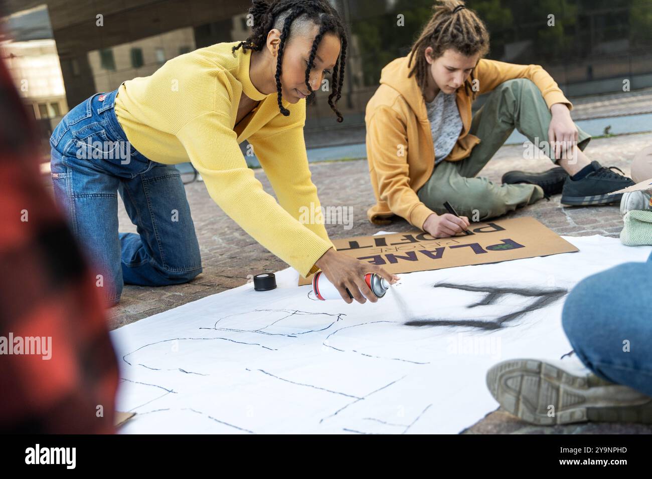 Young diverse activists working together to create protest banners and ...