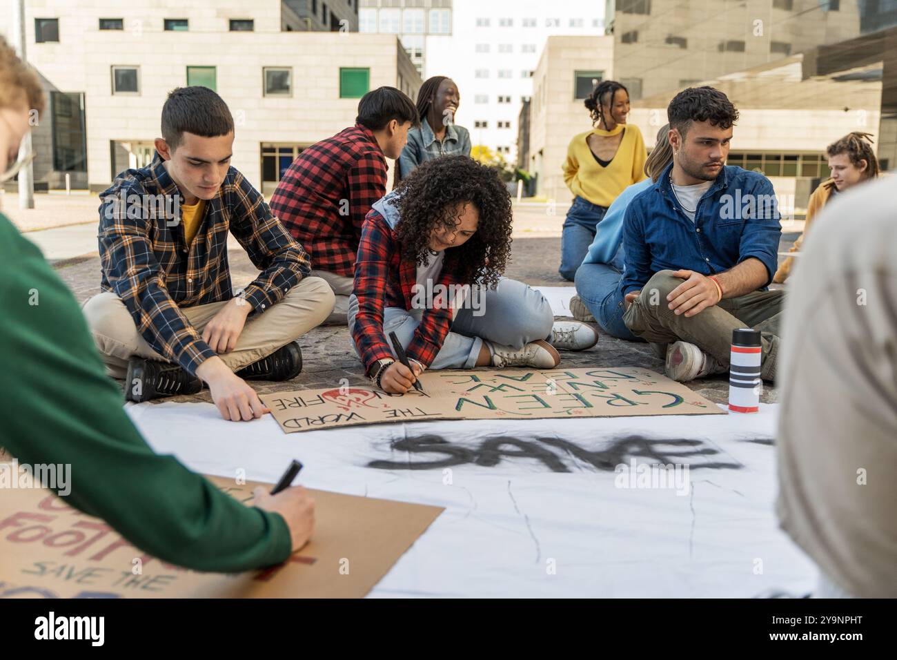 Group of multicultural young people sitting in urban campus, creating ...