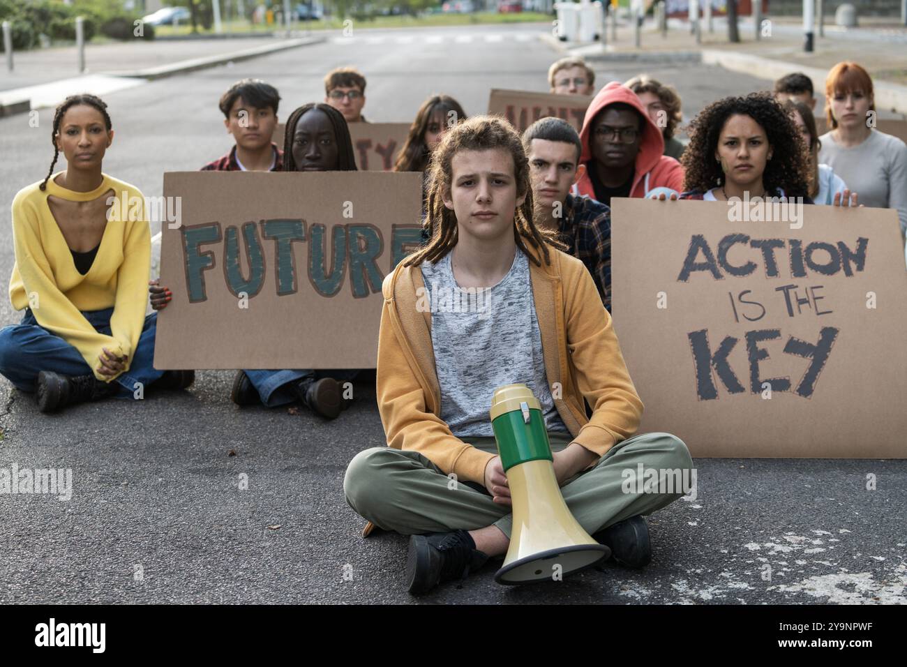 Group of diverse young people participating in a sit-in protest ...