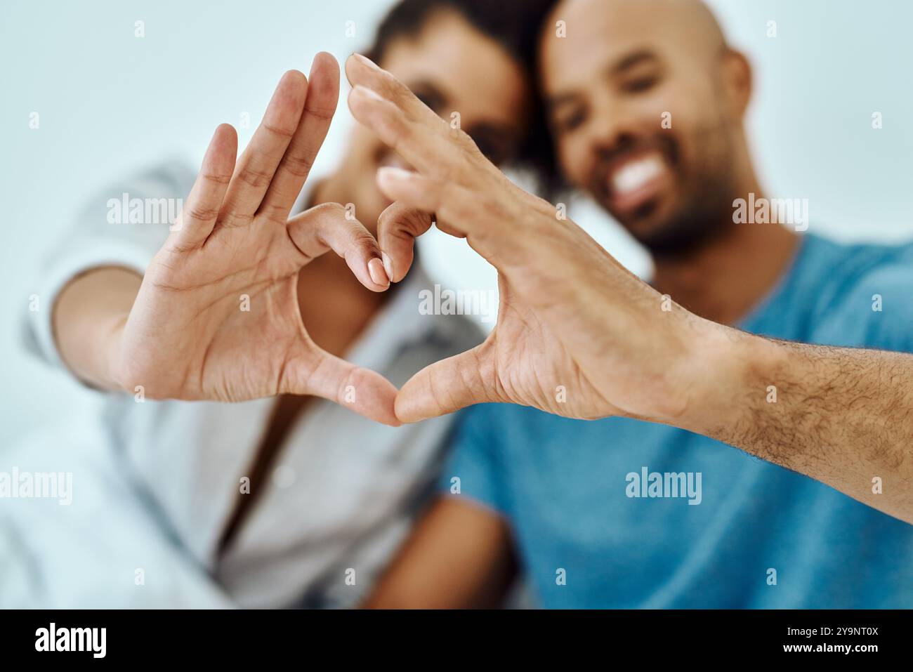 Couple, heart hands and love in bedroom with sign, smile and connection ...