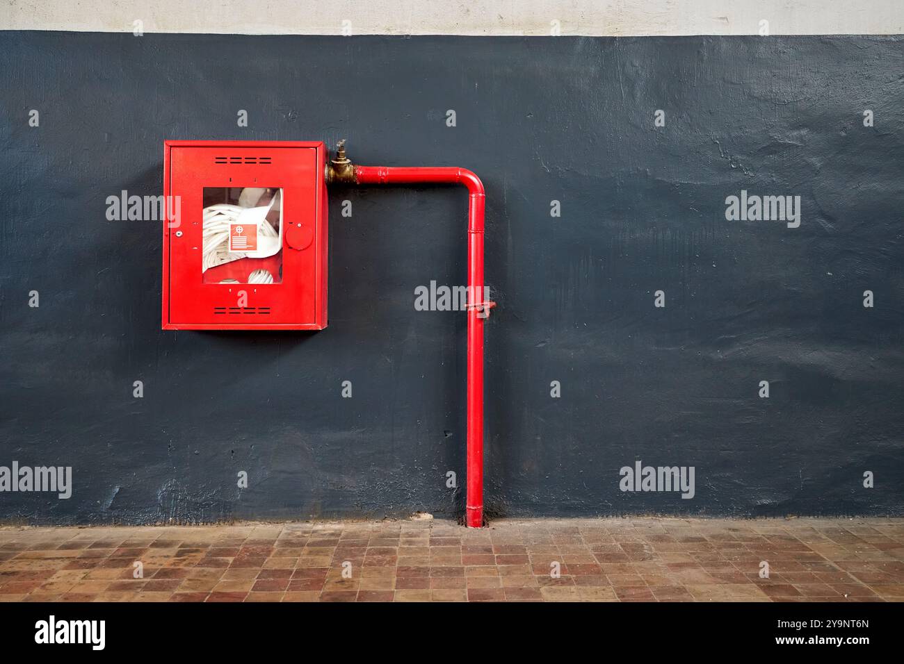 Fire hose in red box. Pipe roll for fire emergency in red metal cabinet ...