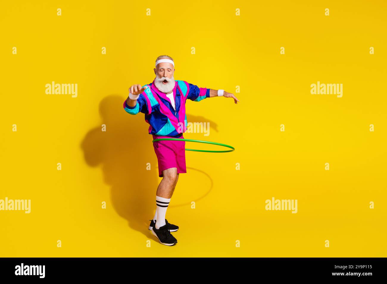 Full body portrait of eccentric aged man workout hula hoop empty space ...