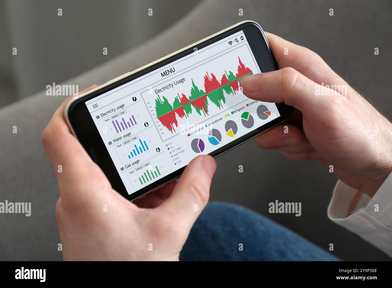 Man monitoring smart meter readings on mobile phone at home, closeup ...