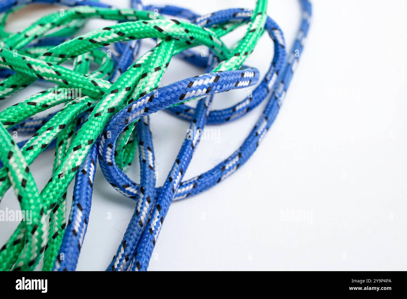 Tangled blue and green strings on white background with empty space ...
