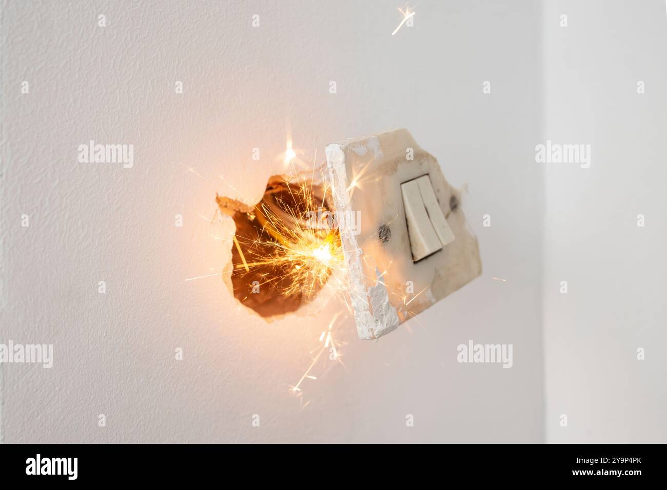 Short circuit sparks and flame in a striped broken outlet on a white ...