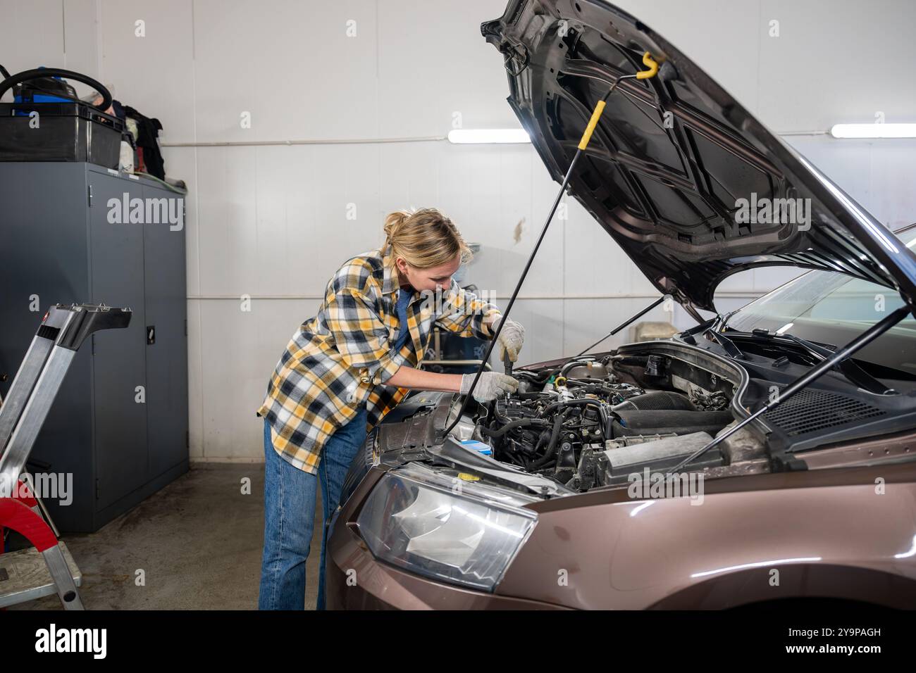 female mechanic working on a car in garage Stock Photo - Alamy