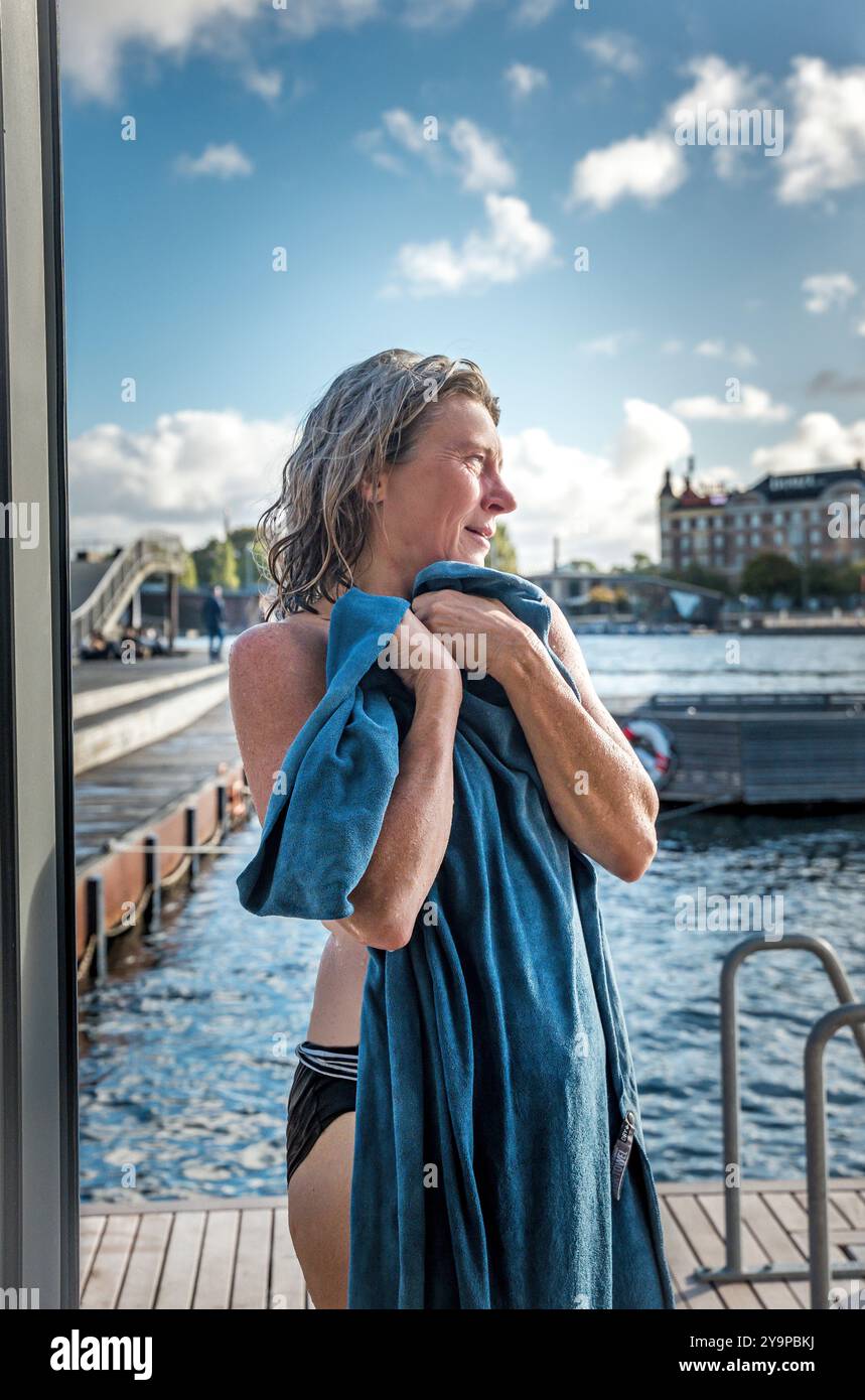 Woman Covering Body With Towel After Swim in Harbor Stock Photo - Alamy