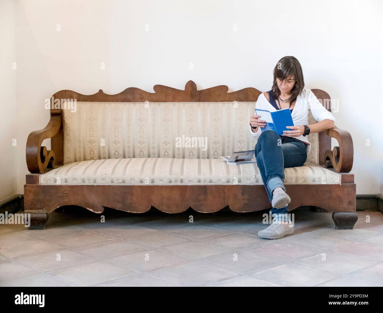 Tourist woman reading guide book while sitting on a vintage bench Stock ...