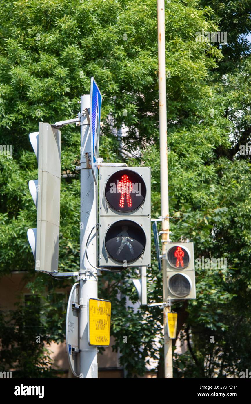 A traffic light with a pedestrian crossing sign is at a city ...