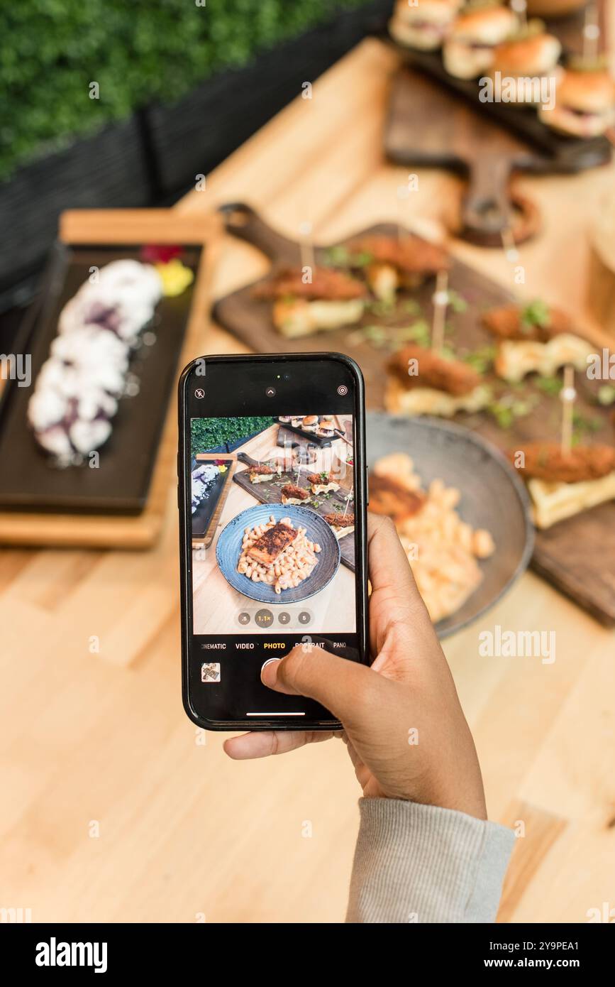 Woman taking a photo of a display of foods Stock Photo - Alamy