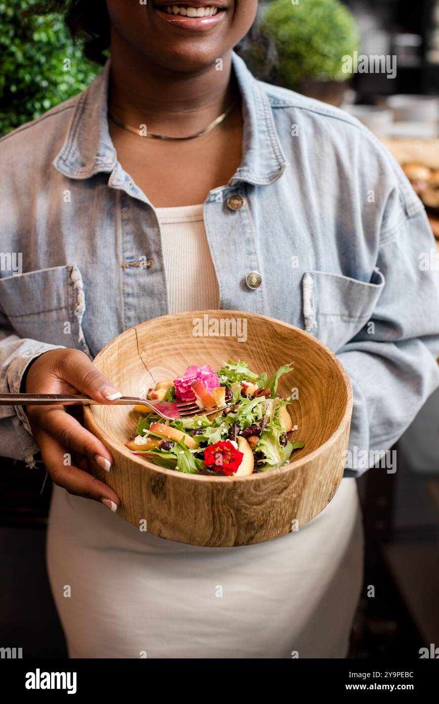 Woman smiling holding a bowl of salad Stock Photo - Alamy