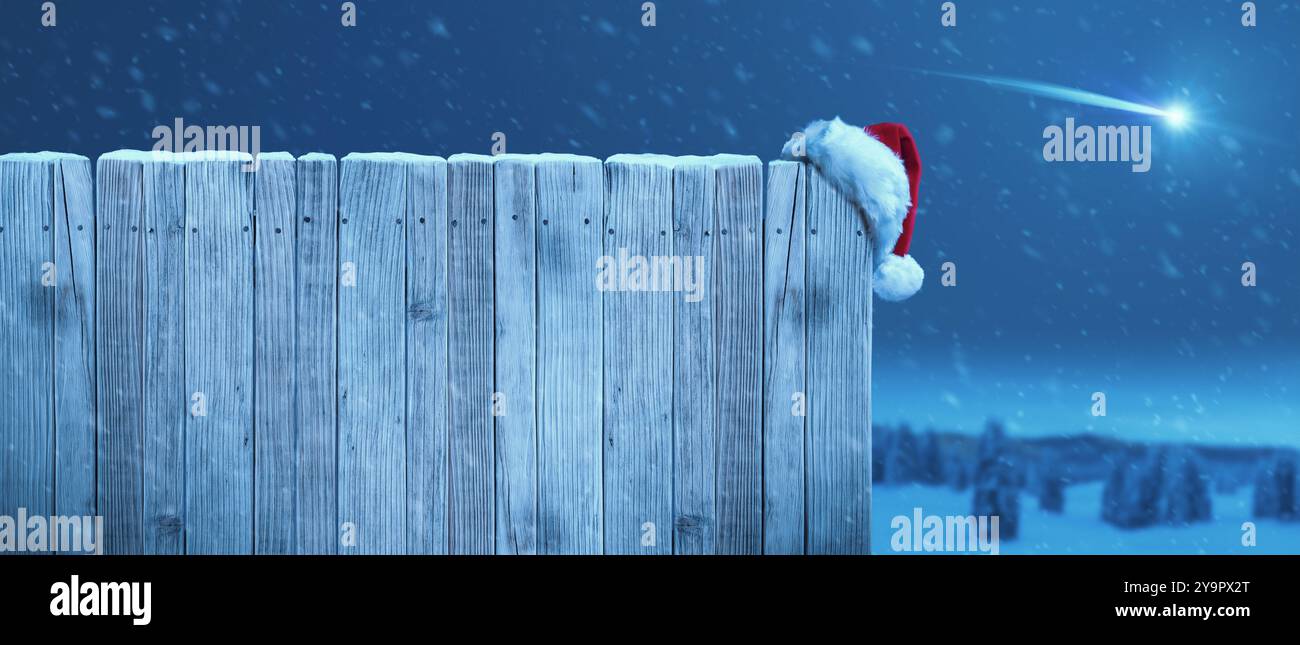 Santa hat on a rustic wooden fence and shooting star in the sky ...